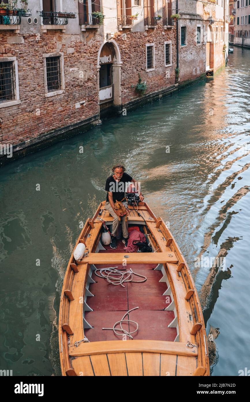 Venice, Italy - May 21, 2022: Local Italian man with a dog driving a ...