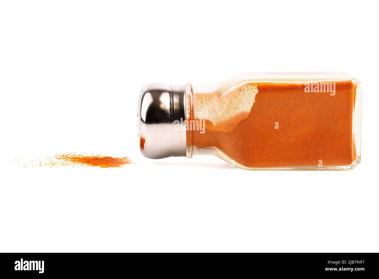 glass pepper pot with ground red pepper dropped on its side isolated on ...
