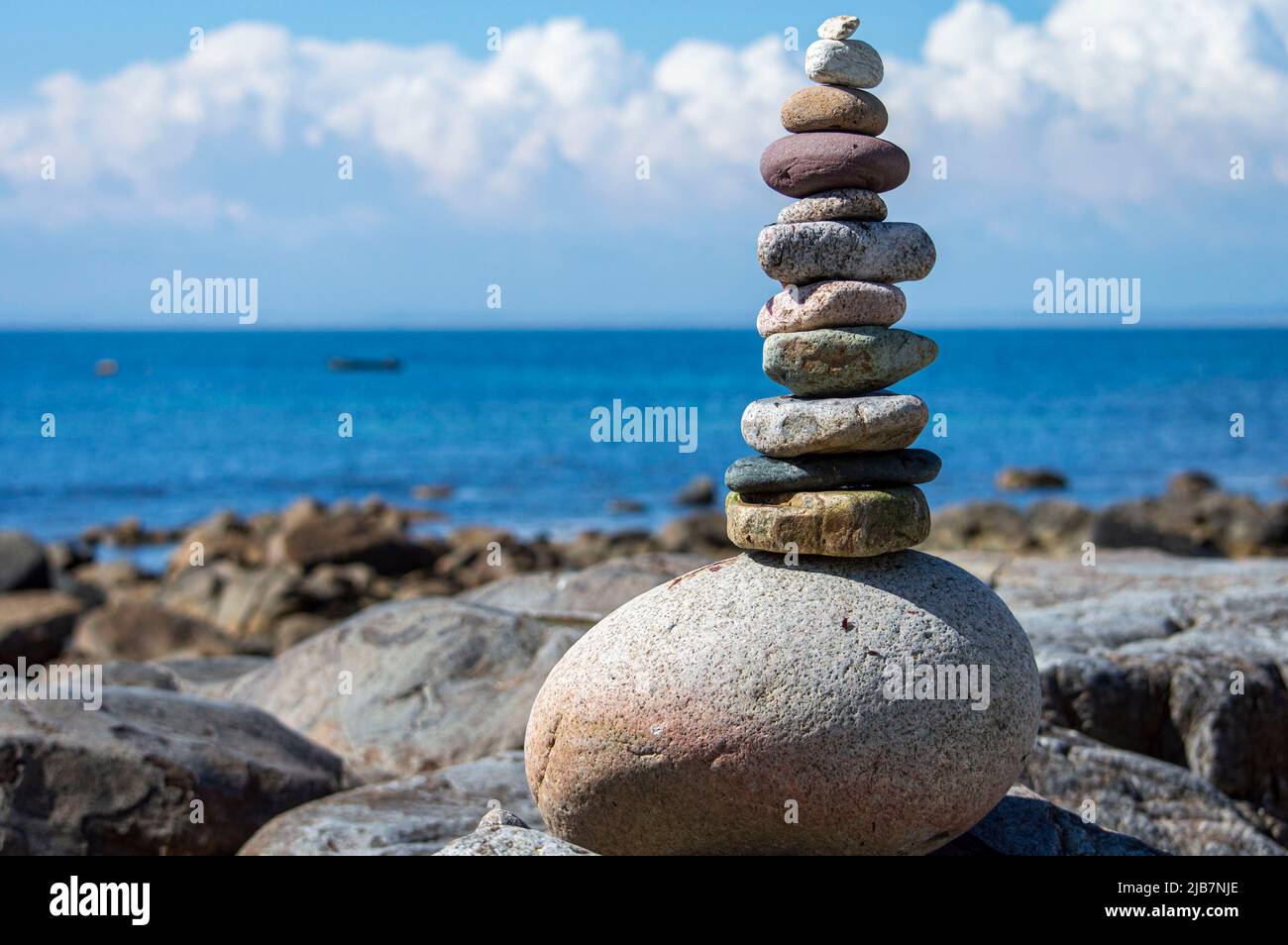 Stack of stones near the sea with cloud and blue sky background Stock ...