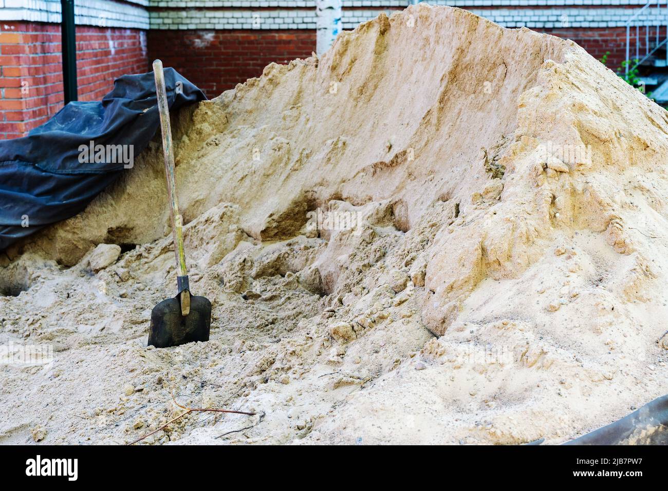a pile of yellow river sand with a shovel on a construction site Stock ...