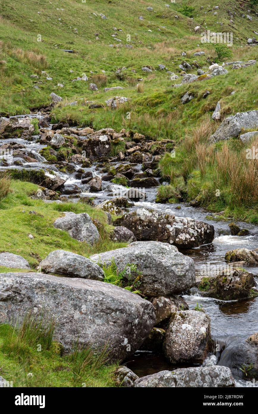 runoff water flows over rocks and boulders in a mountain pass in the ...