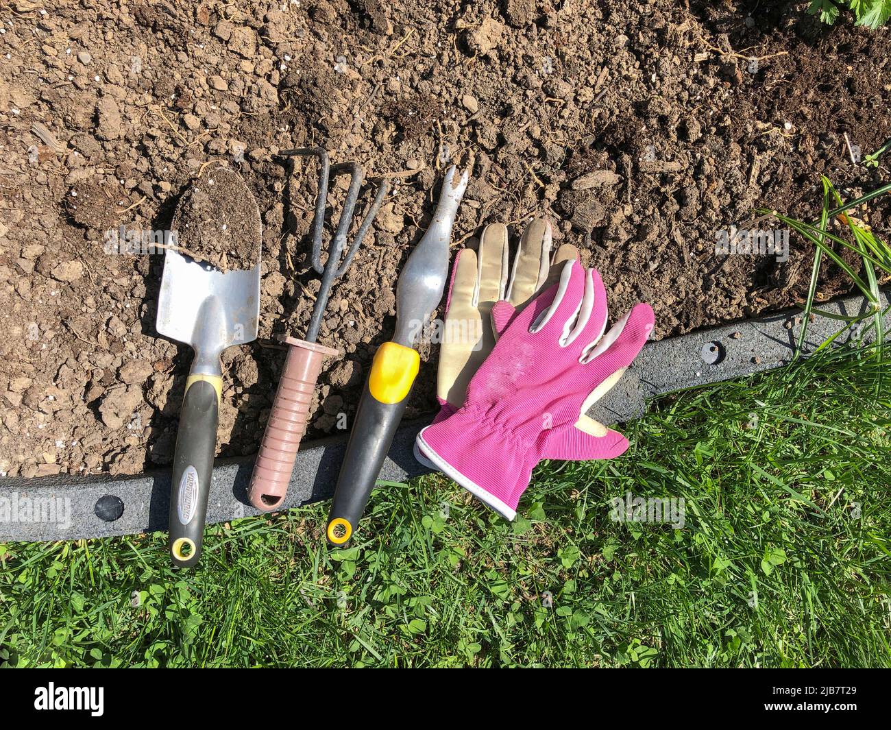 . Gardening tools: - shovel, rake and gloves lie on the ground Stock ...