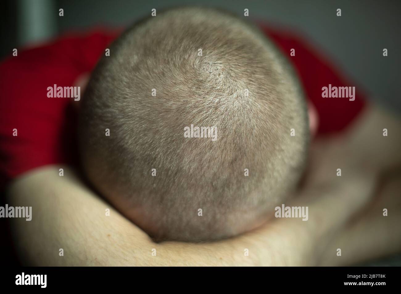 Guy sleeps from fatigue. Man fell asleep with his head on table. Lot of ...