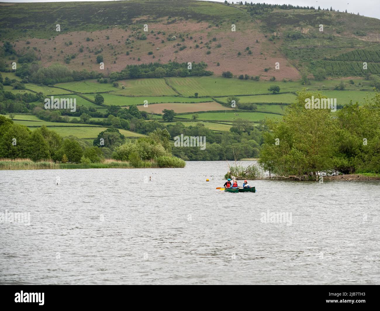 lake with a wooded island and adventure park for water sports, mountain ...