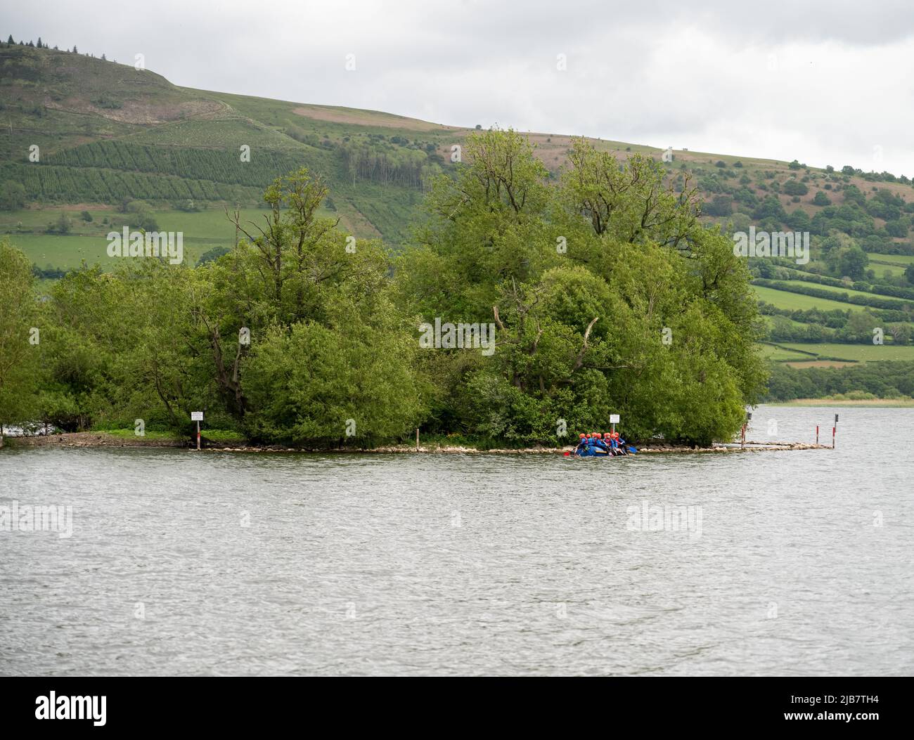 lake with a wooded island and adventure park for water sports, mountain ...