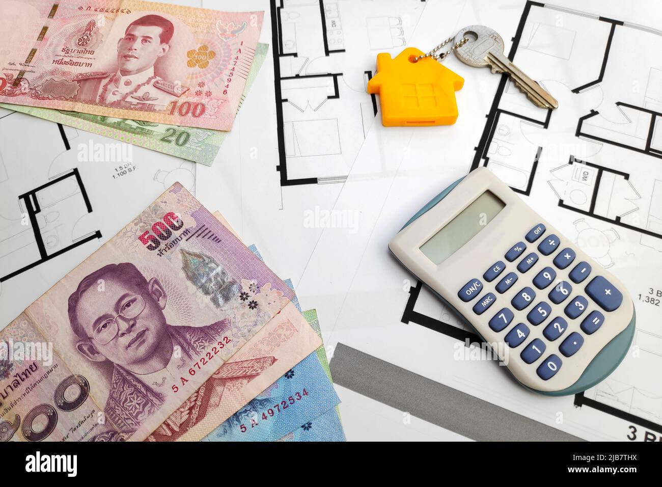 Close-up on some Thai baht, a home key and a calculator on the top of ...