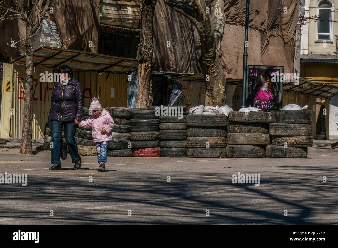 Odessa, Ukraine. 24th Mar, 2022. A woman and her child passing through ...