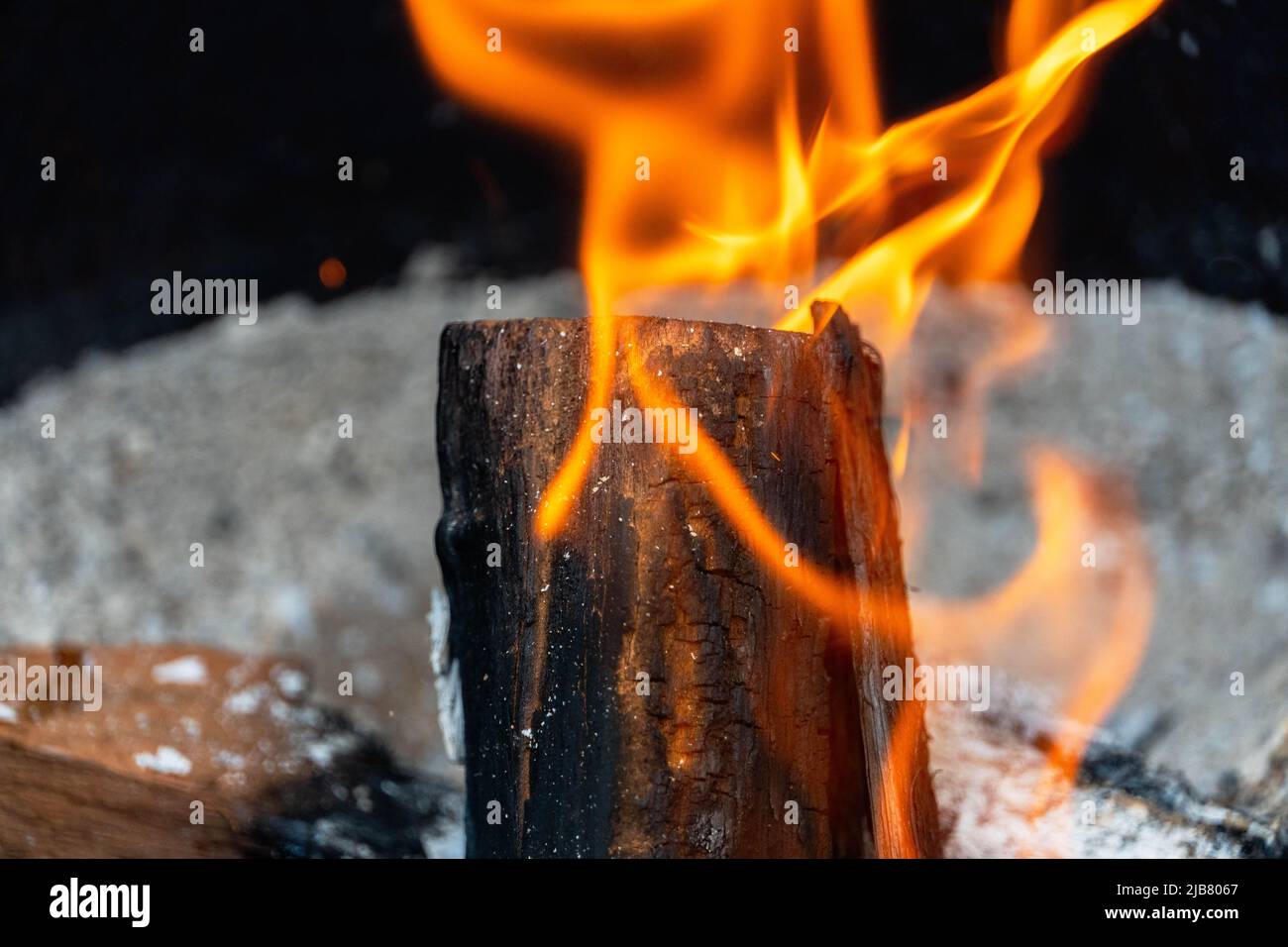 Mesquite dried-wood log emits a massive orange flame inside a large ...