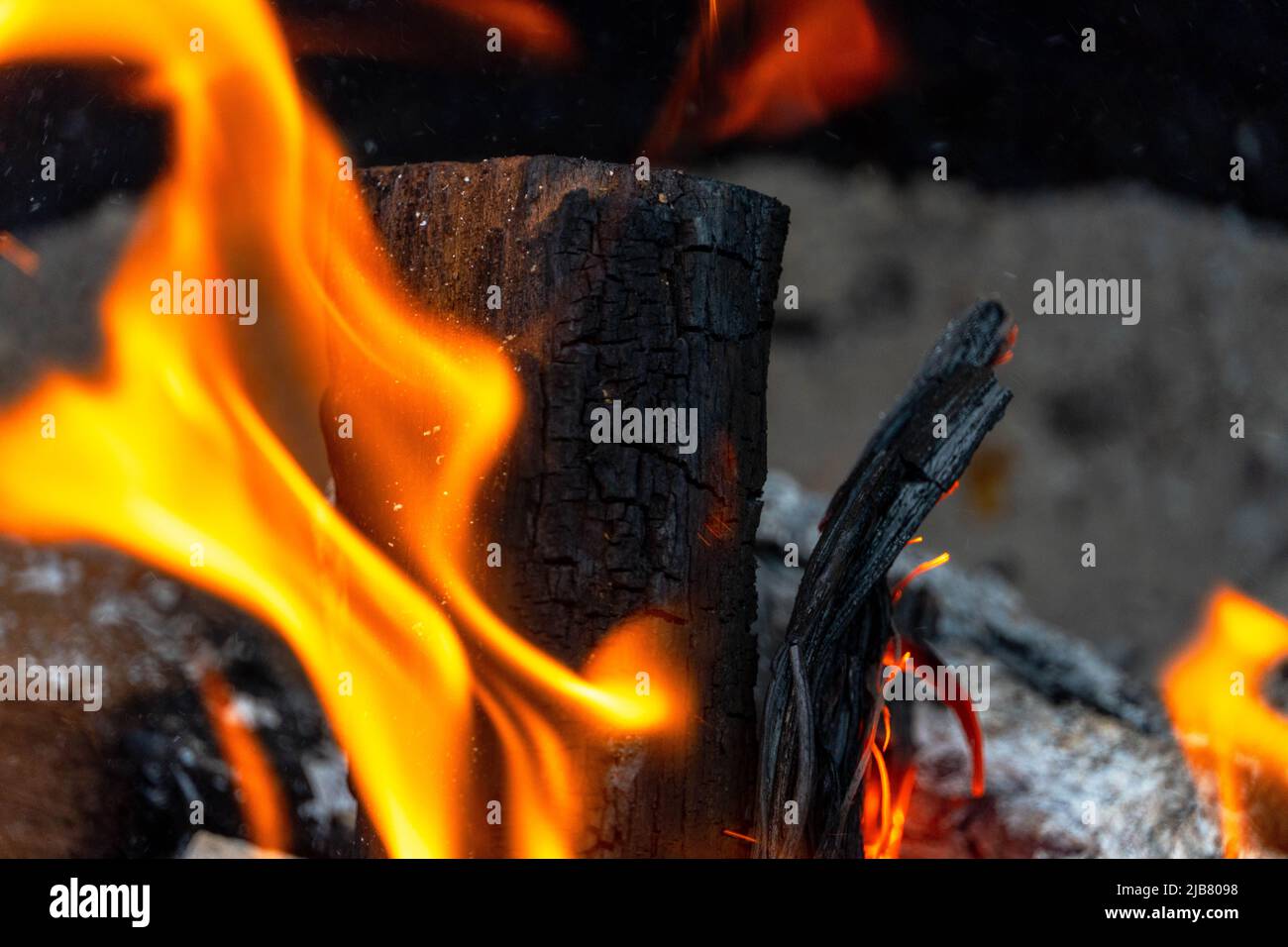 Bright and massive orange flames from a mesquite log in a fire pit ...