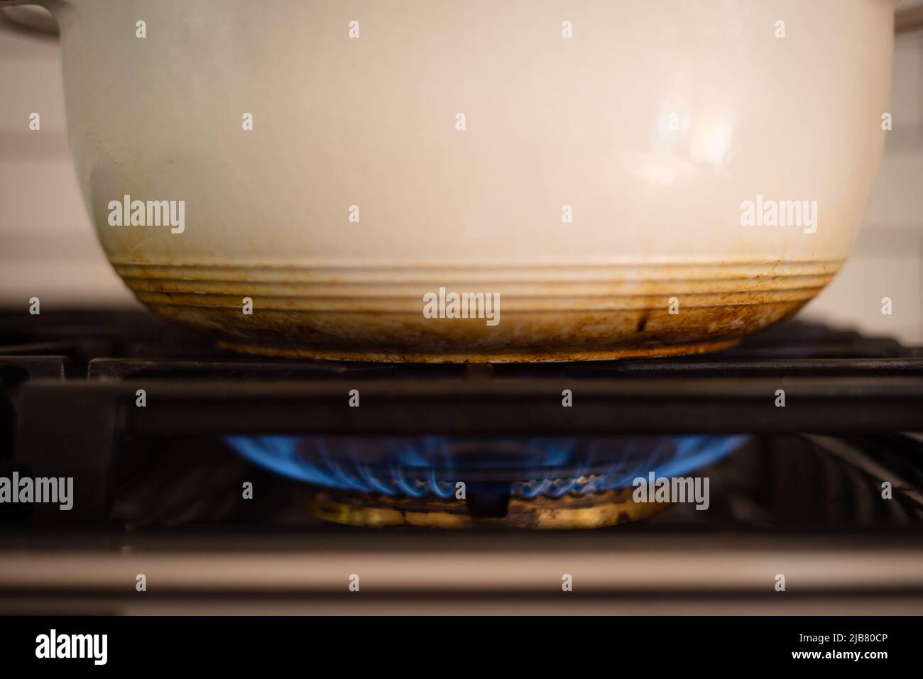 Closeup of cast iron pot on stove showing blue flame Stock Photo - Alamy