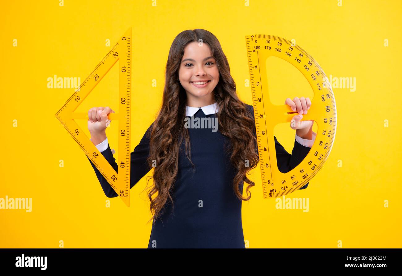 Back to school. School girl hold ruler measuring isolated on yellow ...