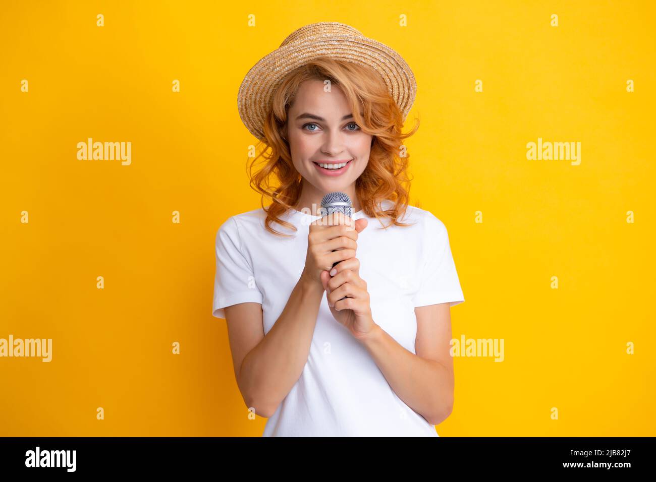 Young pretty woman singing a song with a microphone, presenting an ...