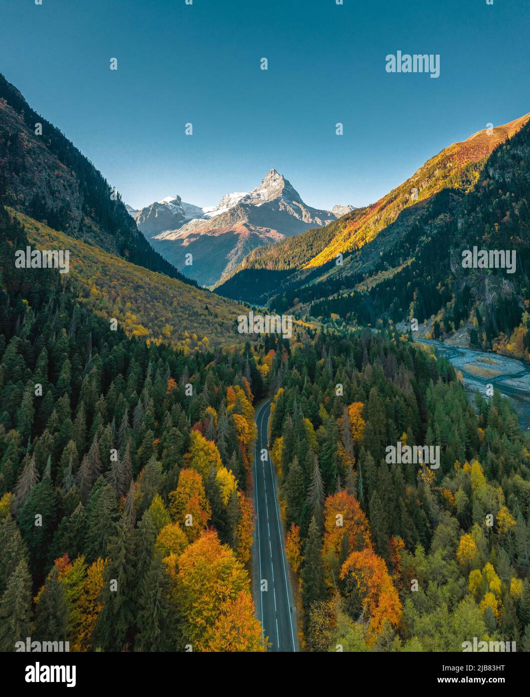 High angle aerial view of river and road running through forest and ...