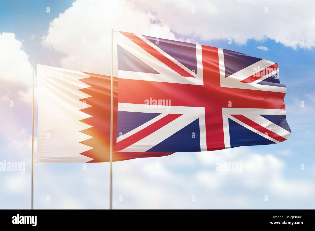 Sunny blue sky and flags of united kingdom and qatar Stock Photo - Alamy