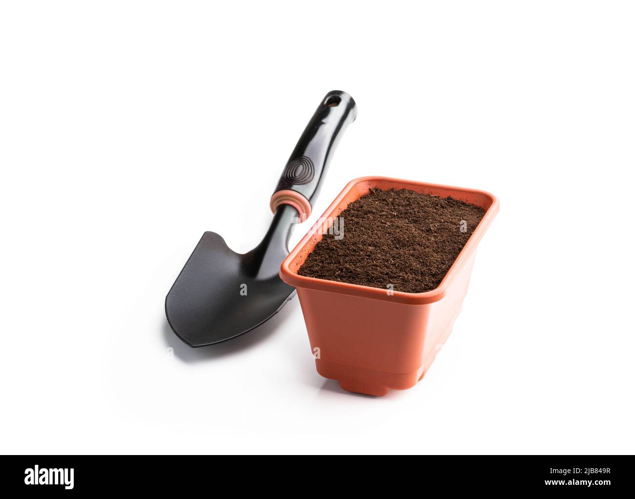 Rectangular pot filled with soil and garden shovel isolated on white ...