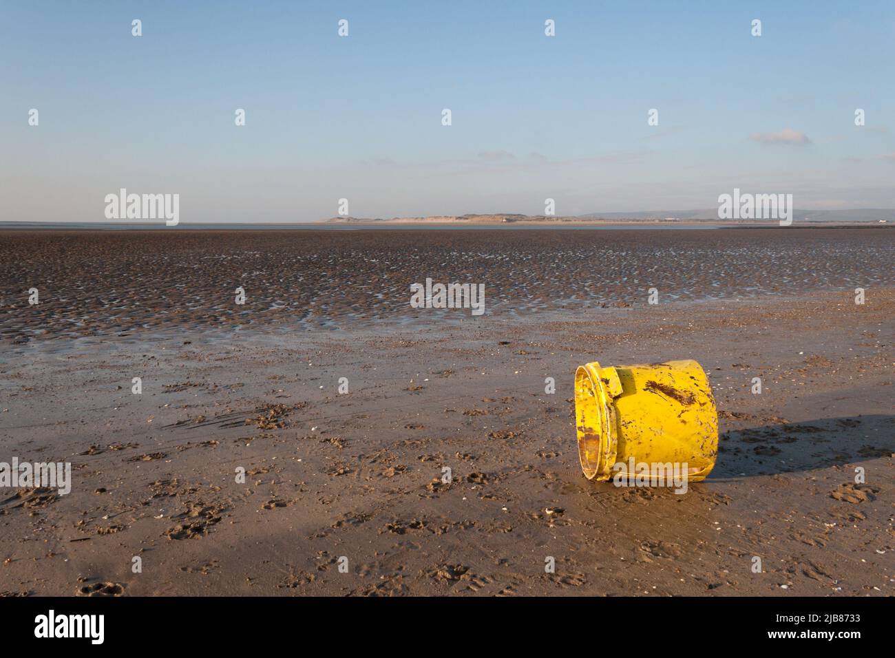 A yellow plastic bucket litters the beach at Instow, Devon Stock Photo ...