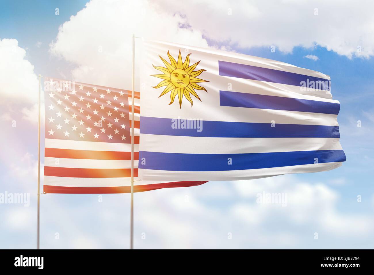 Sunny blue sky and flags of uruguay and usa Stock Photo - Alamy