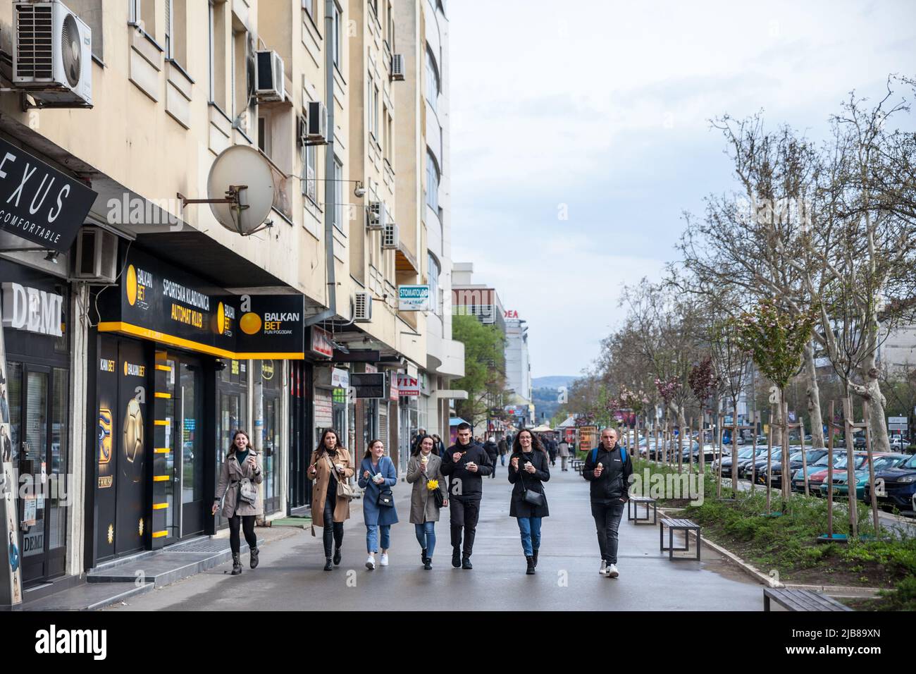Picture of a group of young people, adults, female, walking and eating ...