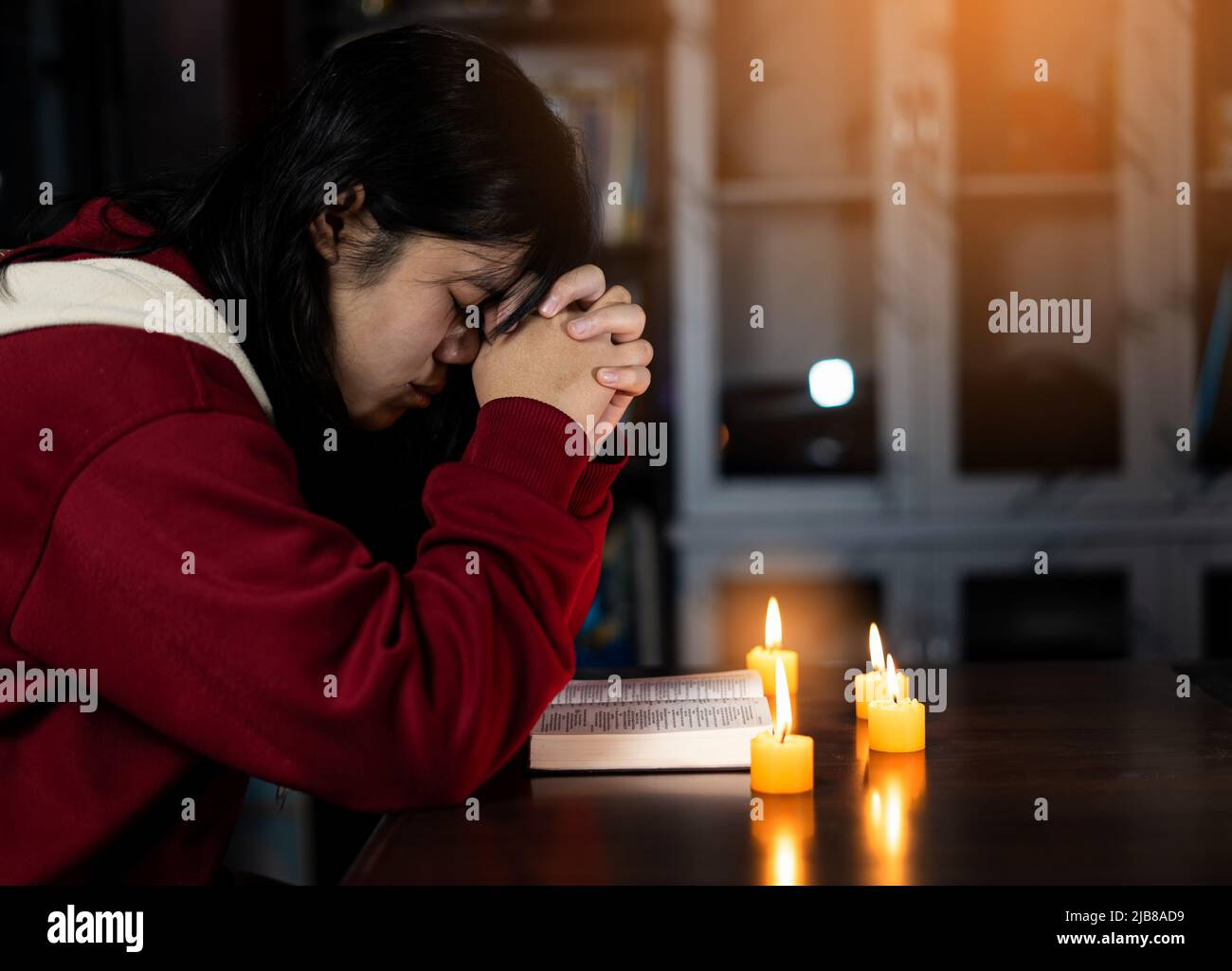 Christian female while praying and worship for Jesus with candle stick ...