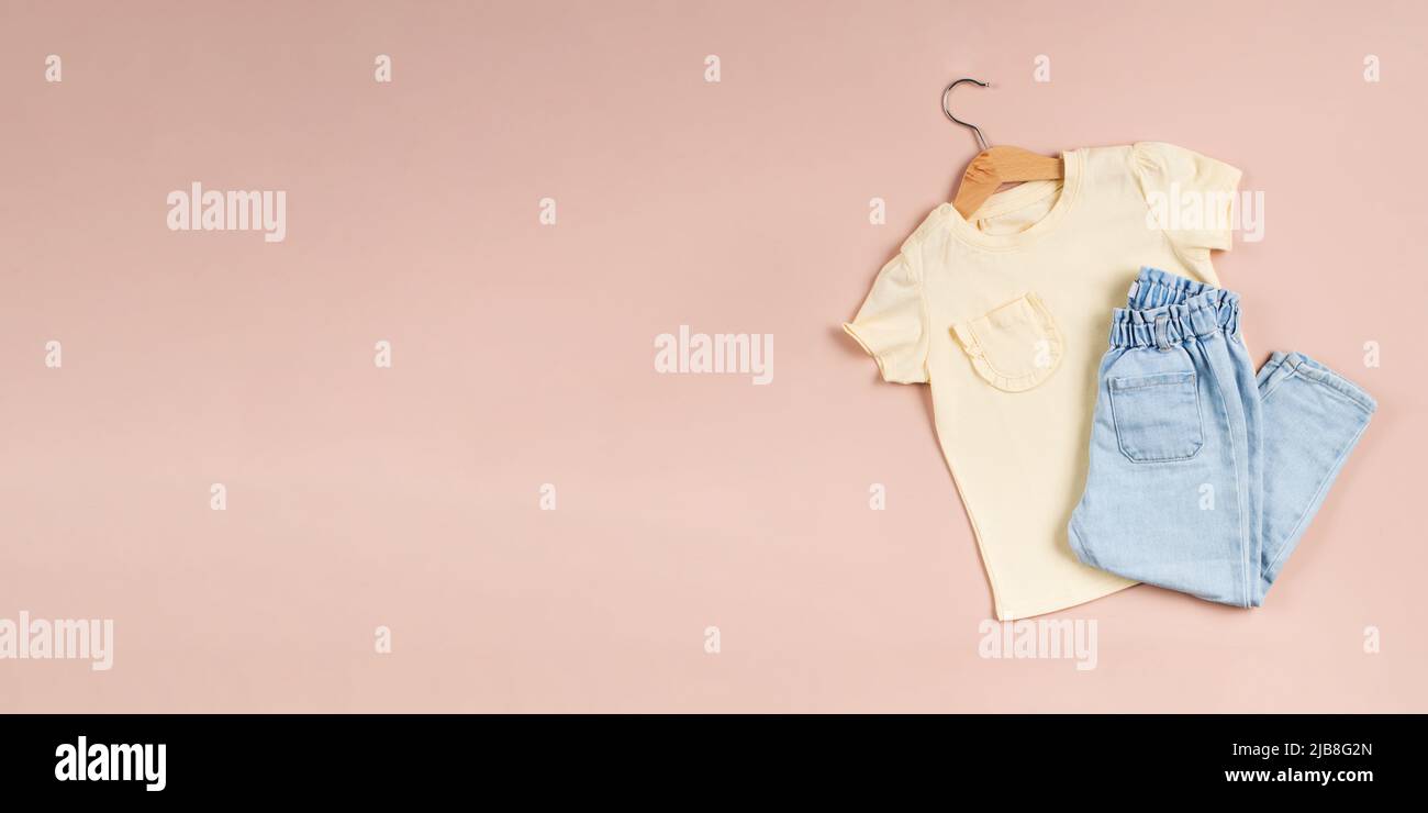 Childish image with jeans and a yellow t-shirt on a pink background ...