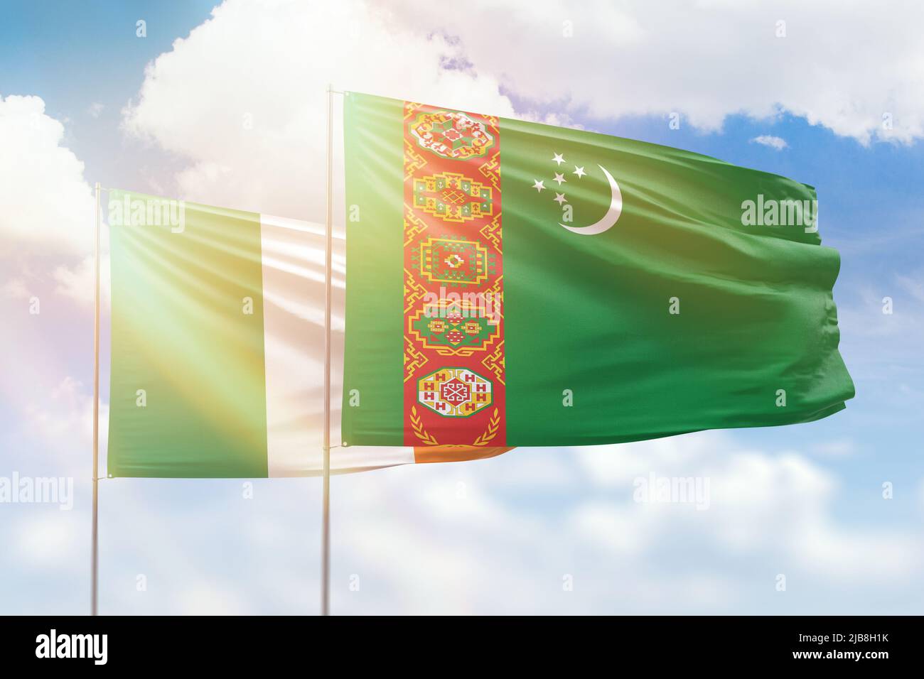 Sunny blue sky and flags of turkmenistan and ireland Stock Photo - Alamy