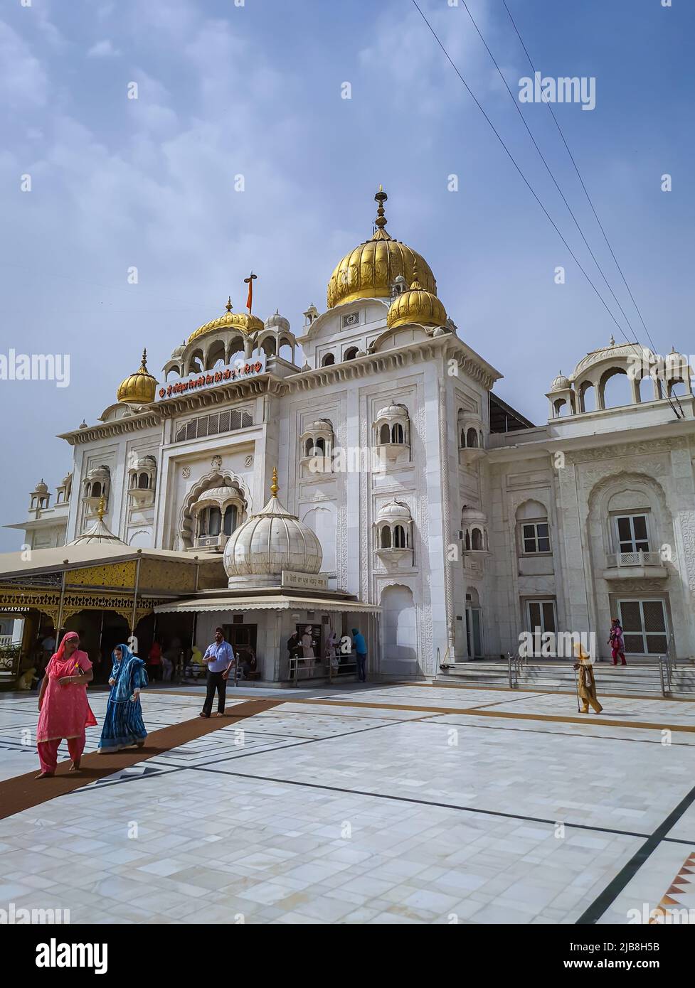 isolated gurudwara building with golden dome and flat sky at morning ...