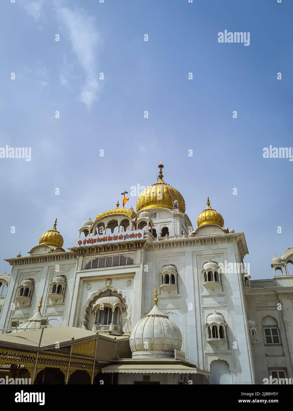 isolated gurudwara building with golden dome and flat sky at morning ...