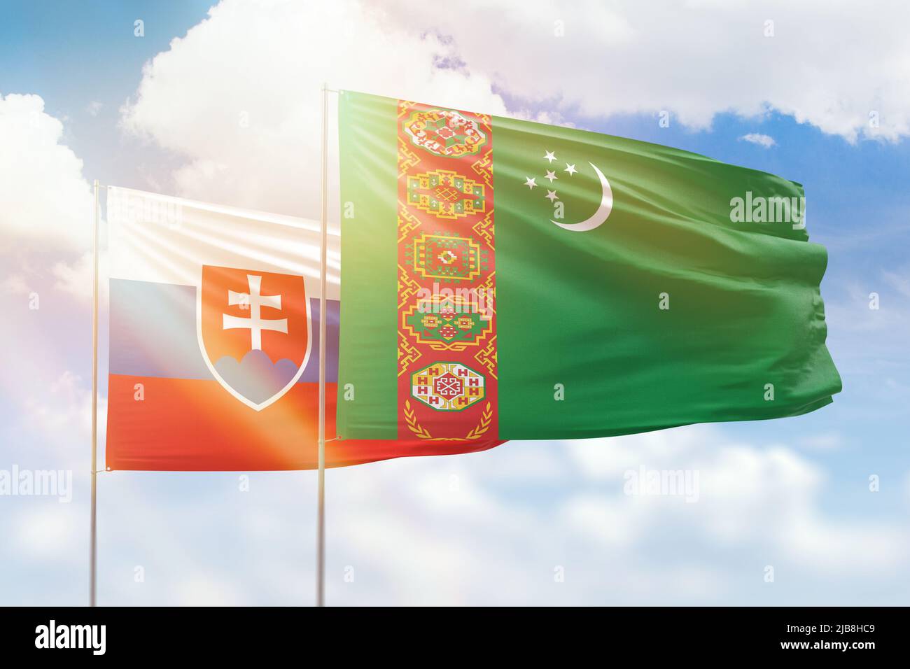 Sunny blue sky and flags of turkmenistan and slovakia Stock Photo - Alamy