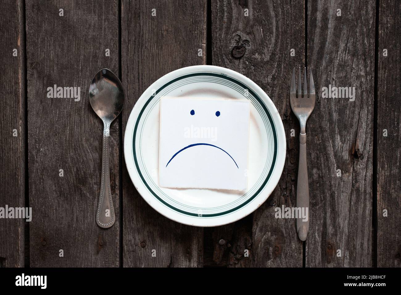 sad udibka drawn on a piece of paper lies on an empty plate on the ...