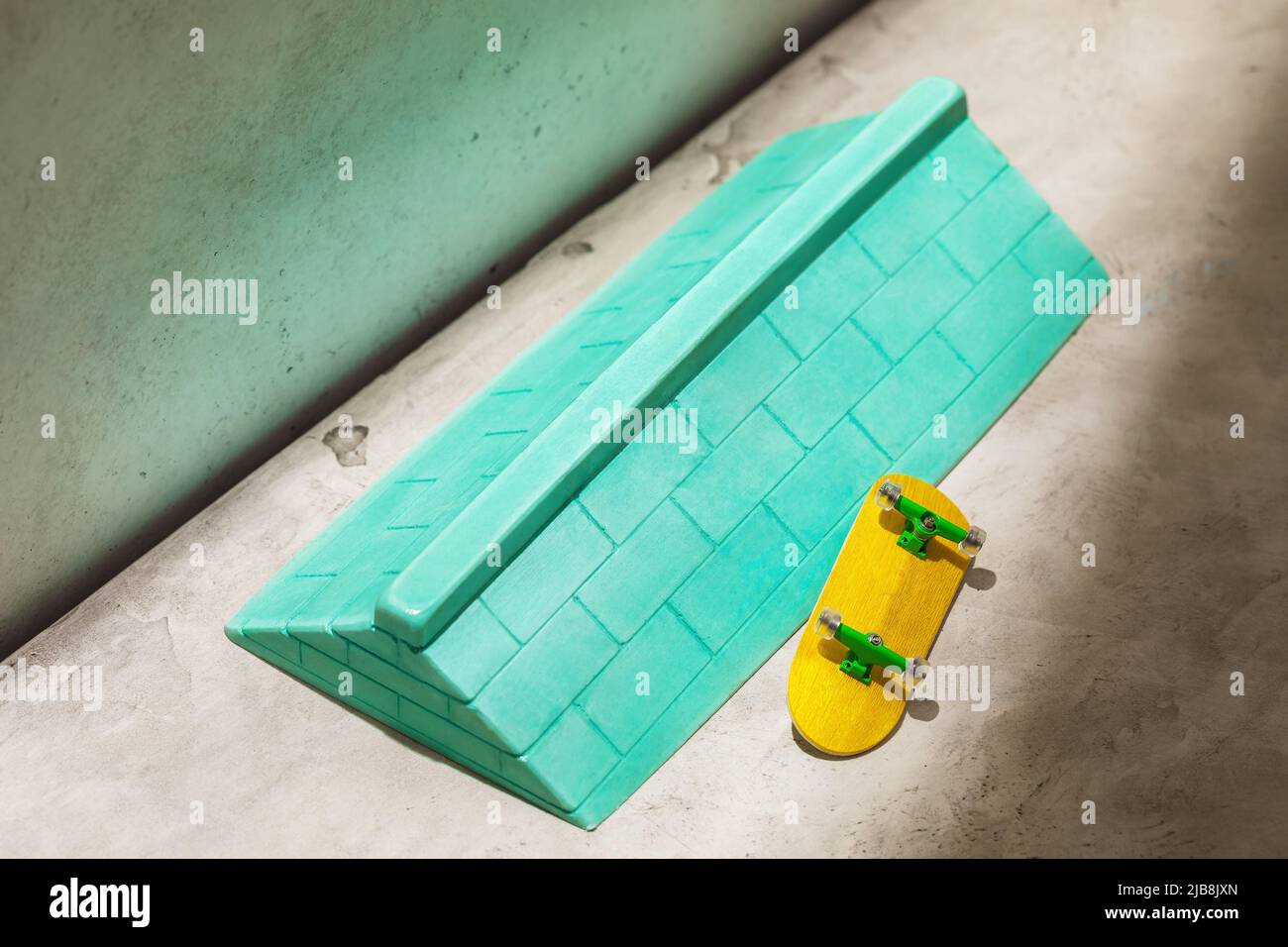 Green plaster ramp with brick wall texture and yellow fingerboard on ...