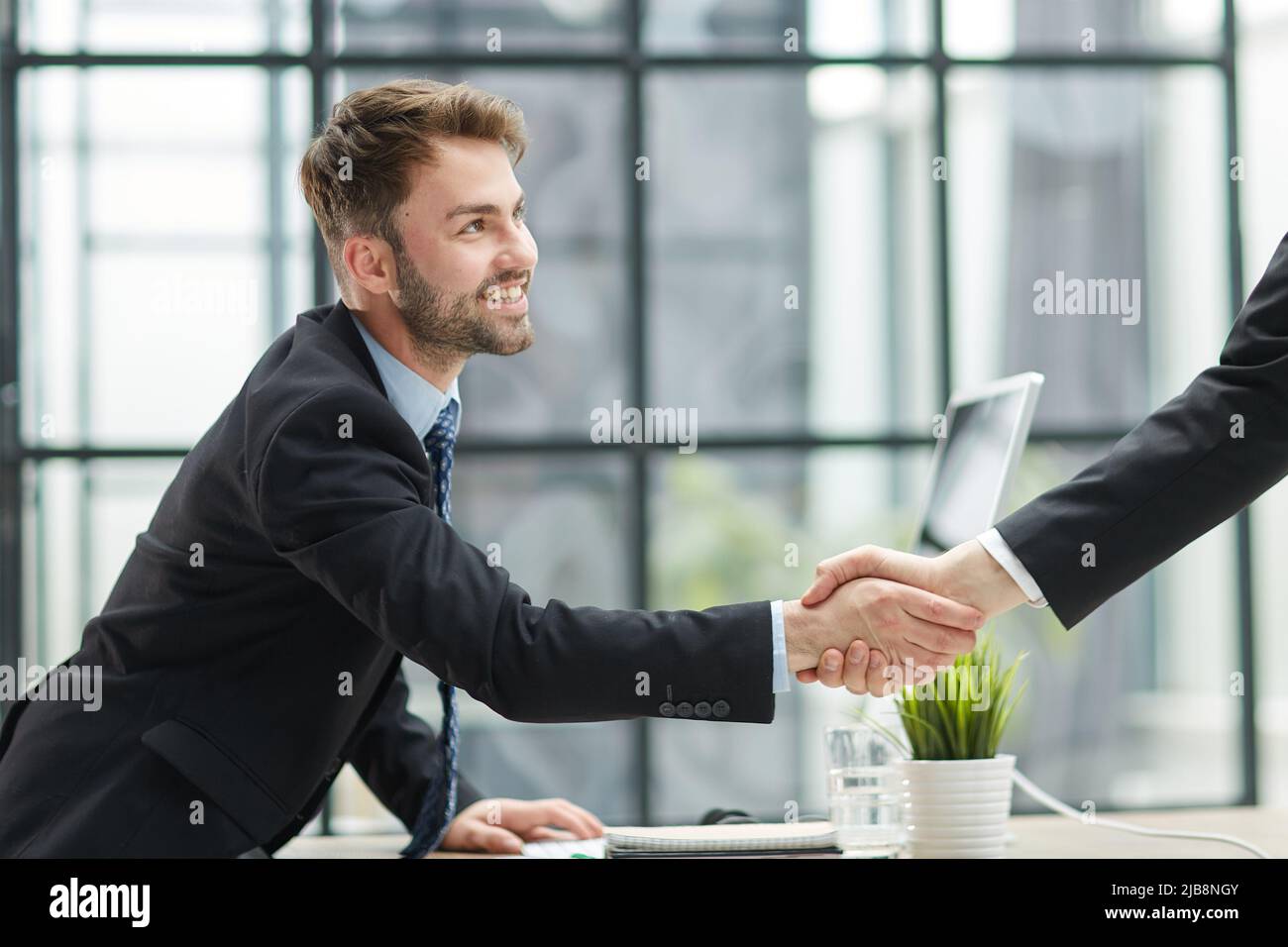 Portrait of cheerful young manager handshake with colleague Stock Photo ...