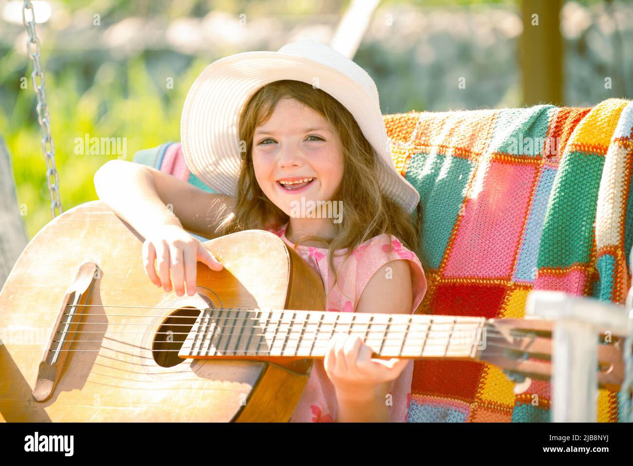 Happy smiling child girl play the guitar. Kids music and songs. Smiling ...