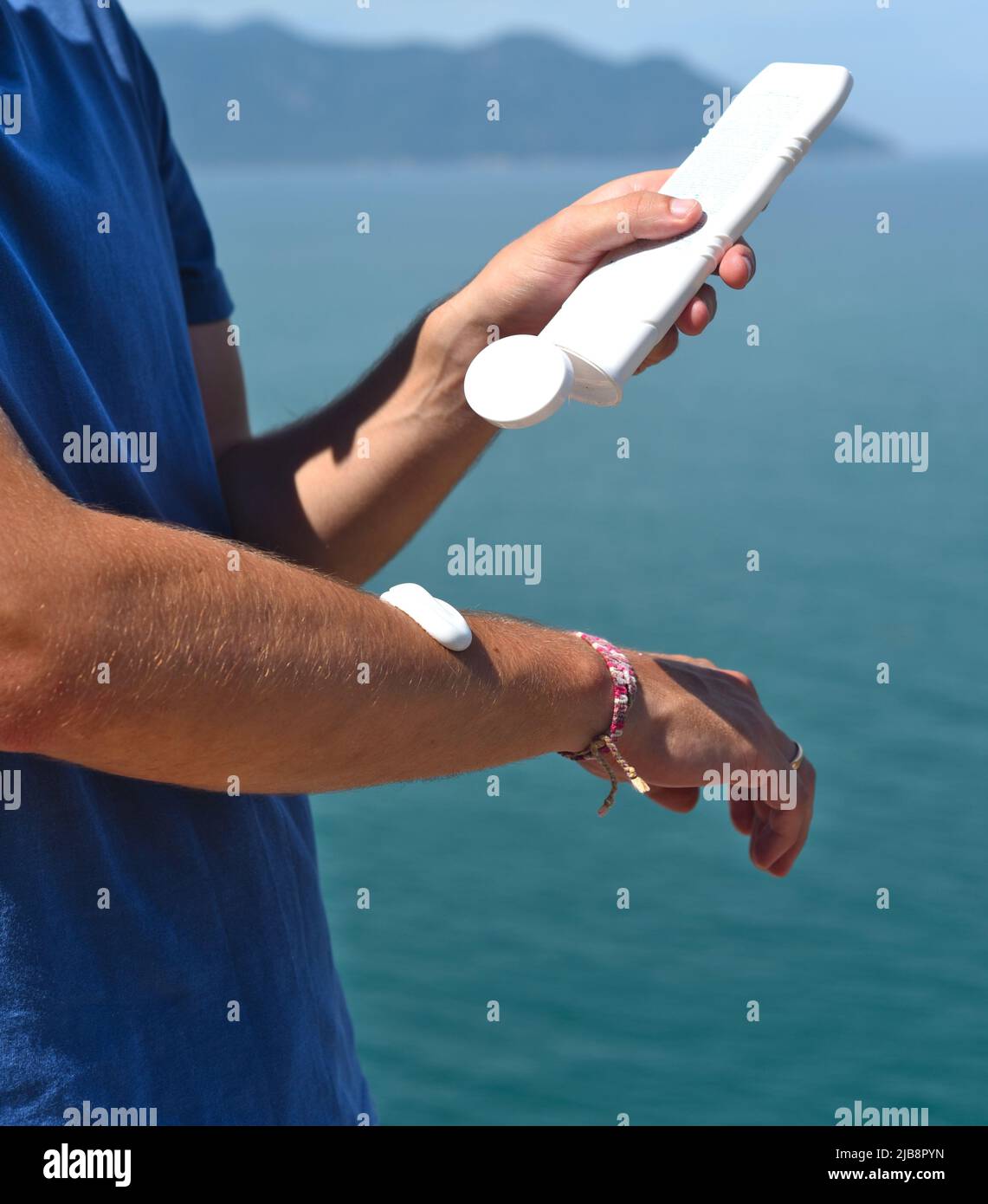 Using sunscreen cream on arm against sea under sunlight Stock Photo - Alamy