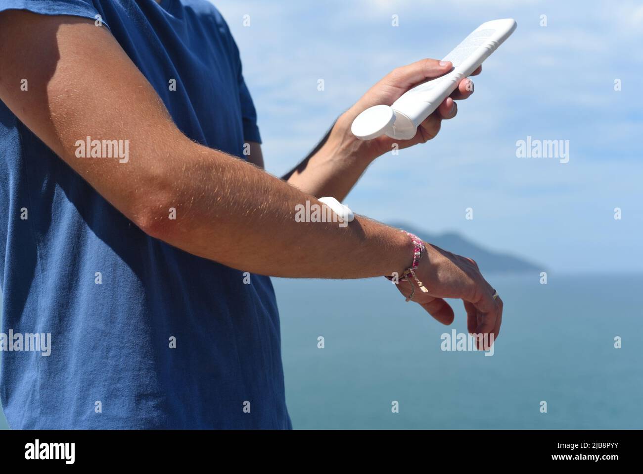 Using sunscreen cream on arm against sea under sunlight Stock Photo - Alamy