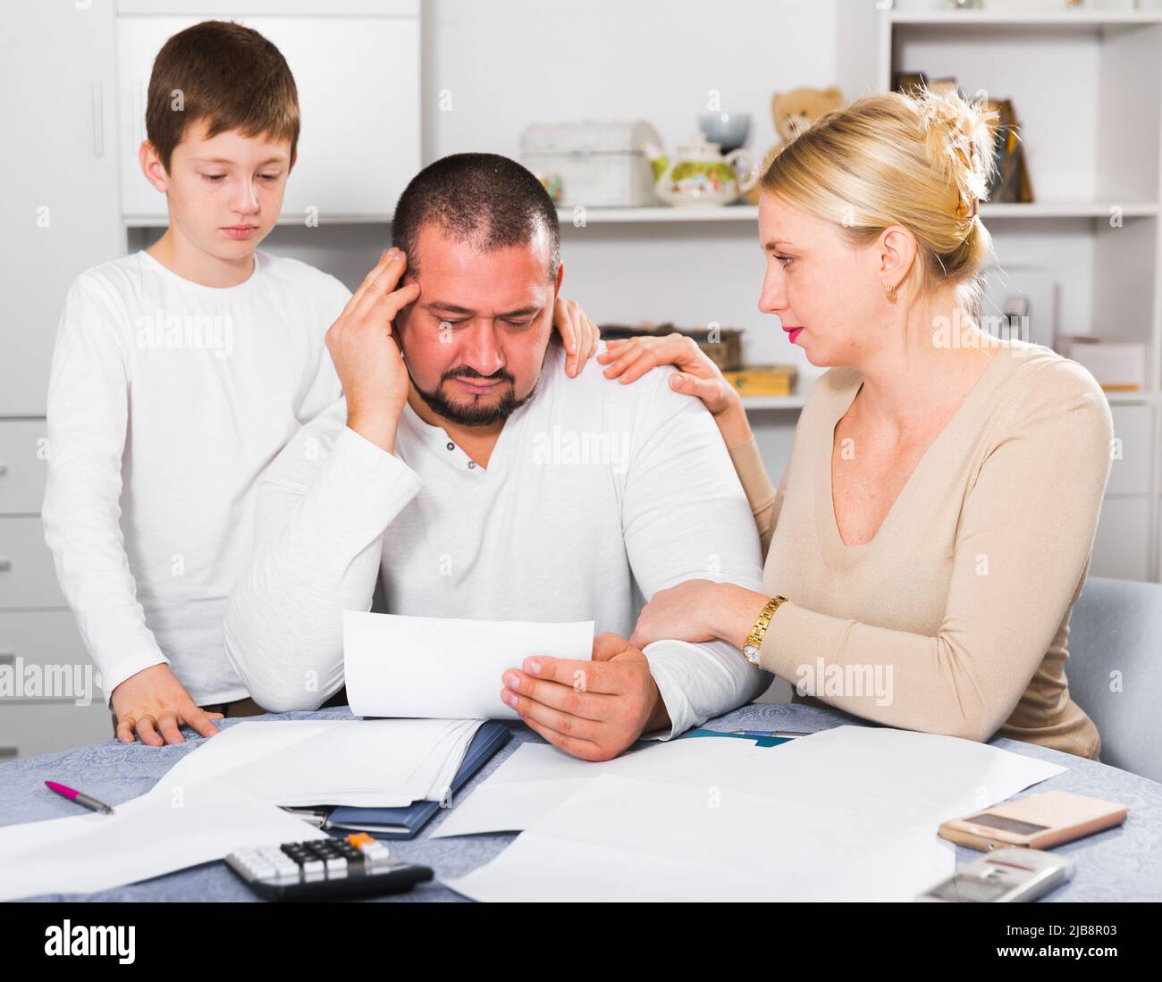 Family soothing chagrined man Stock Photo - Alamy
