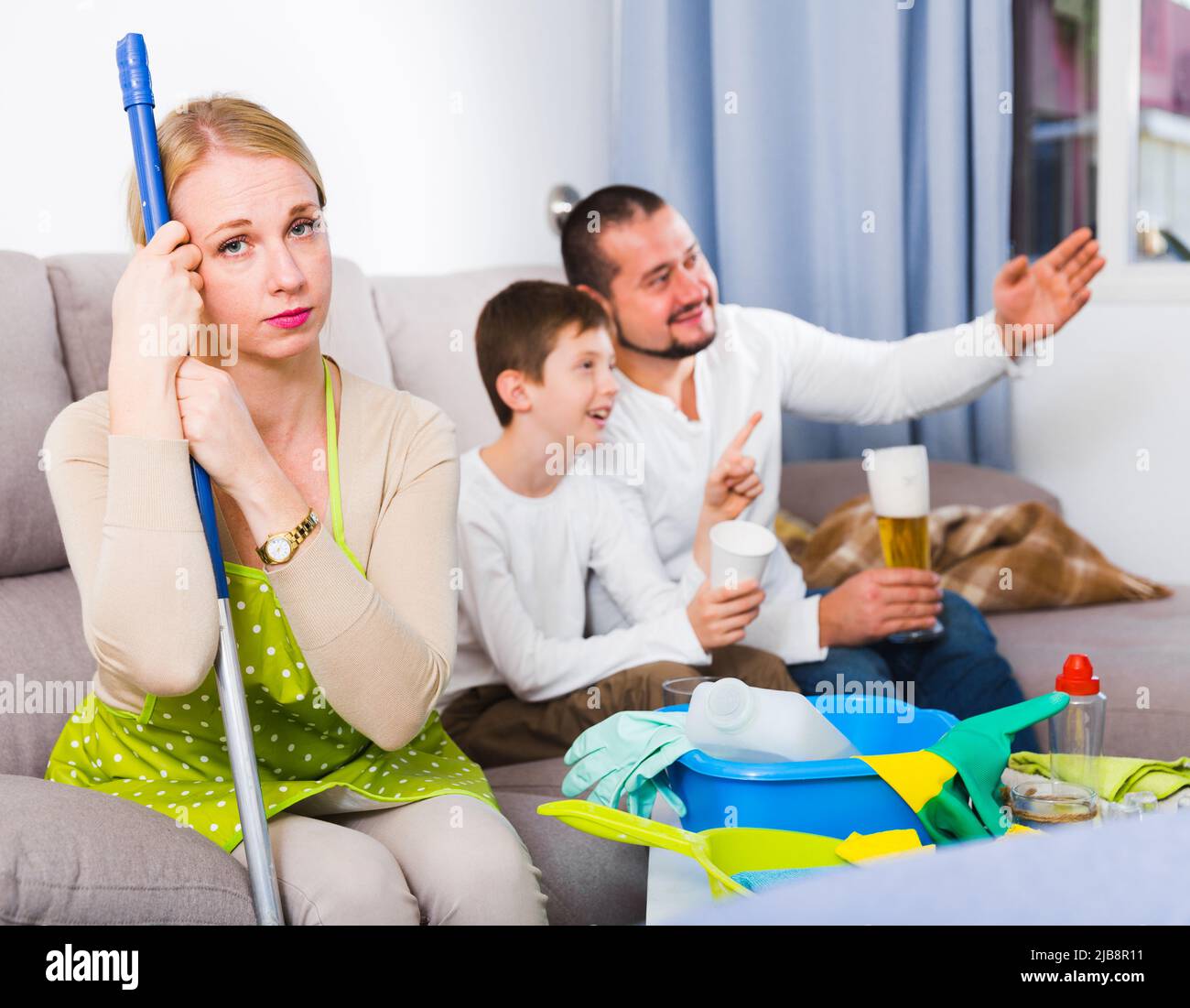 Upset woman with cleaning equipment Stock Photo - Alamy