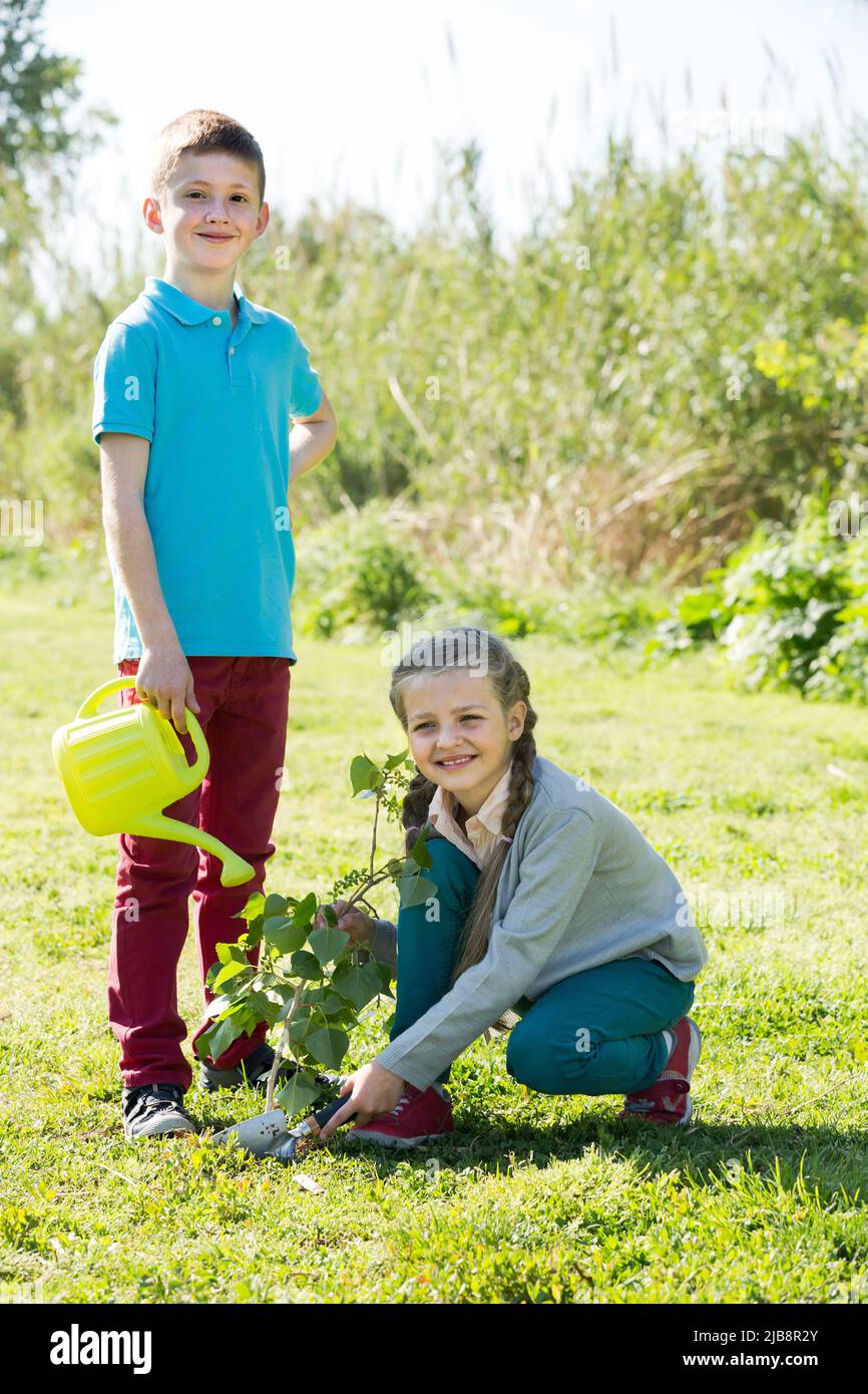 Two children planting a new tree Stock Photo - Alamy