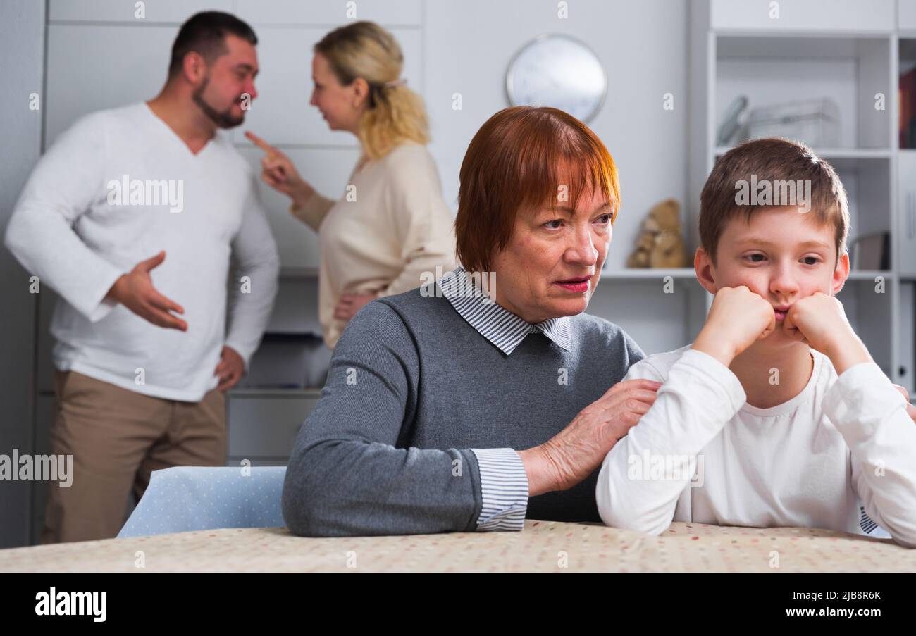 Woman calming boy during parents quarrel Stock Photo - Alamy