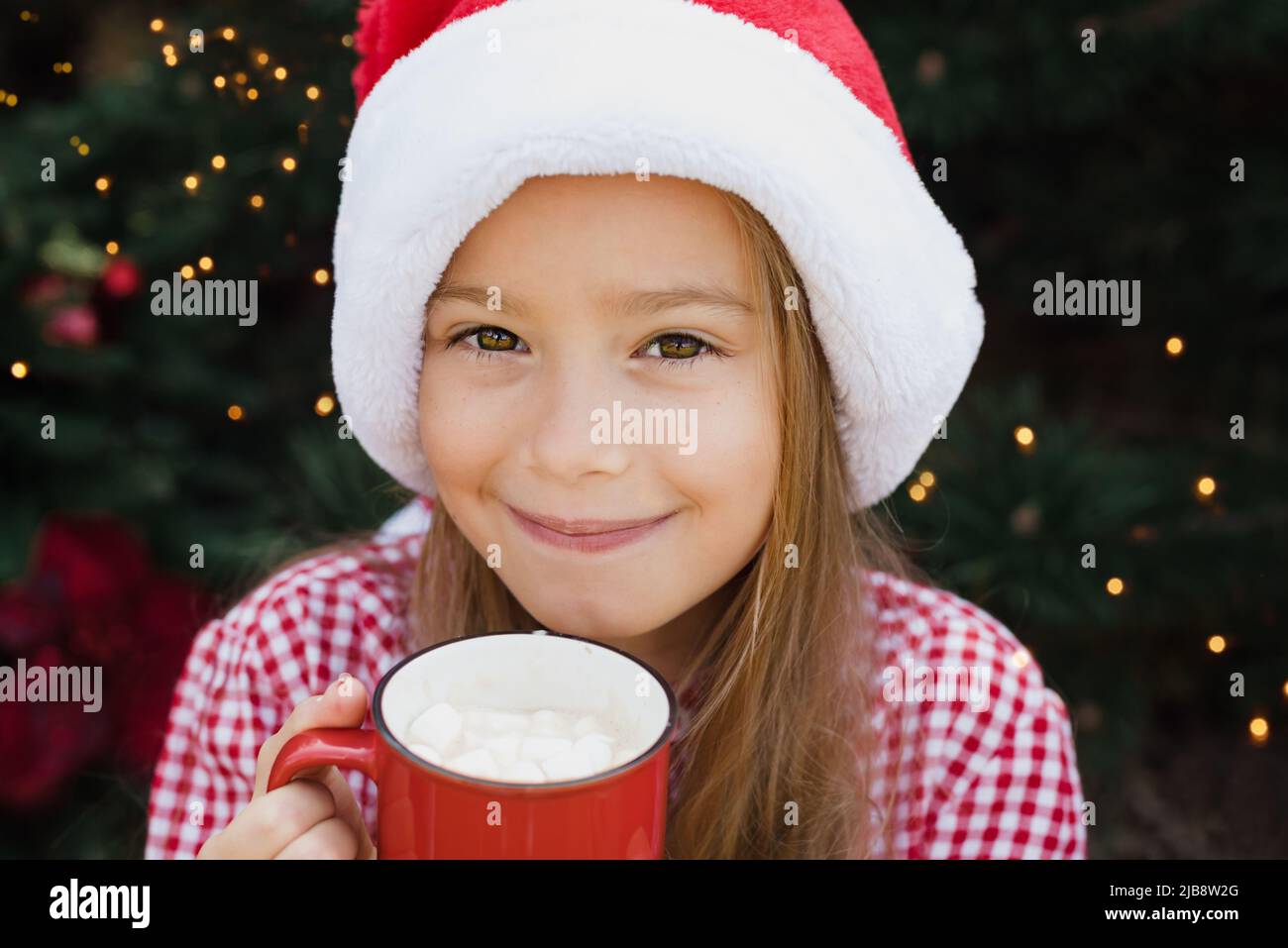 Merry Christmas. Portrait of funny child girl in Santa hat eating ...