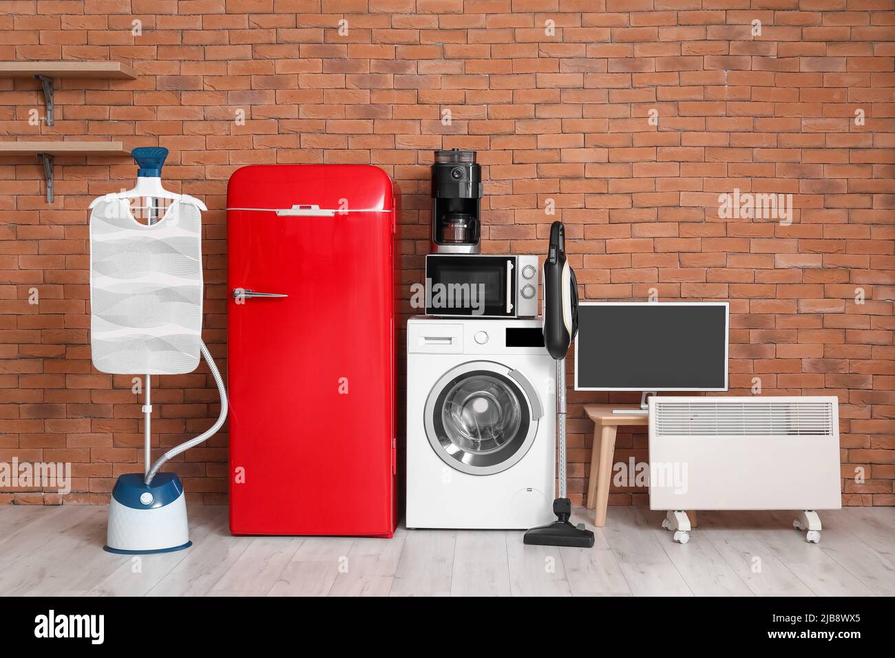 Modern household appliances near brick wall in room Stock Photo - Alamy