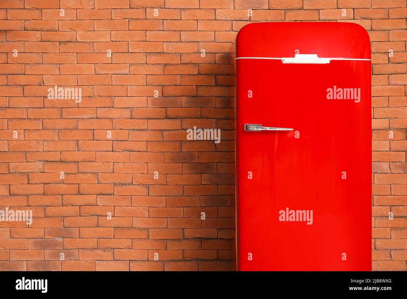 Stylish retro fridge near brick wall in room Stock Photo - Alamy