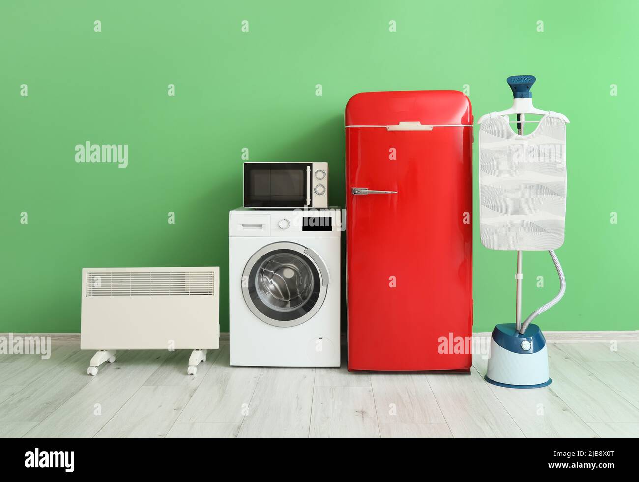 Modern household appliances near green wall in room Stock Photo - Alamy