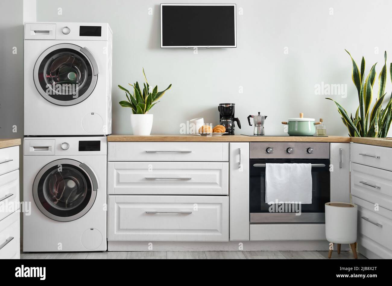 Stylish interior of kitchen with modern washing machines Stock Photo ...