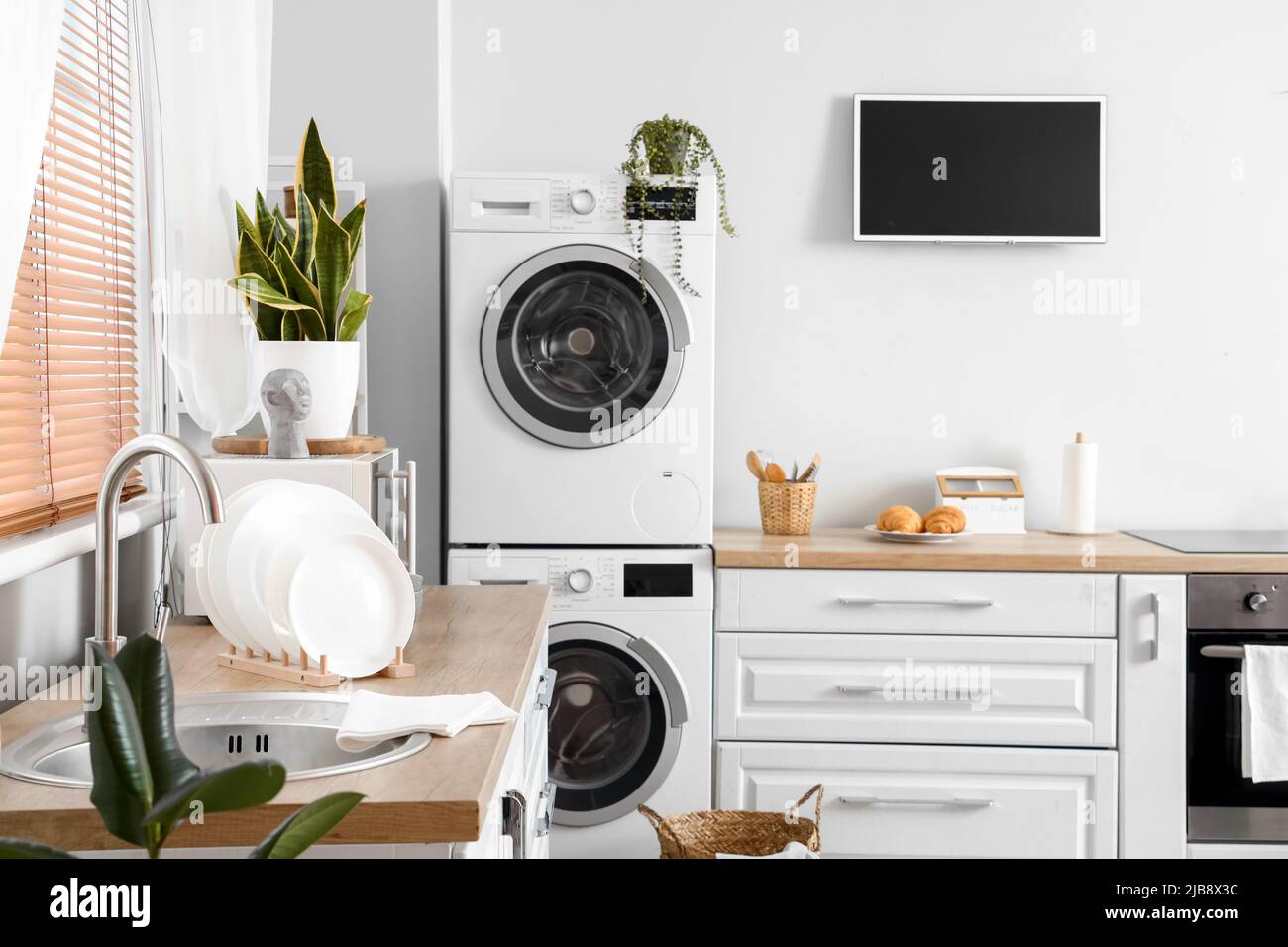 Stylish interior of kitchen with modern washing machines Stock Photo ...