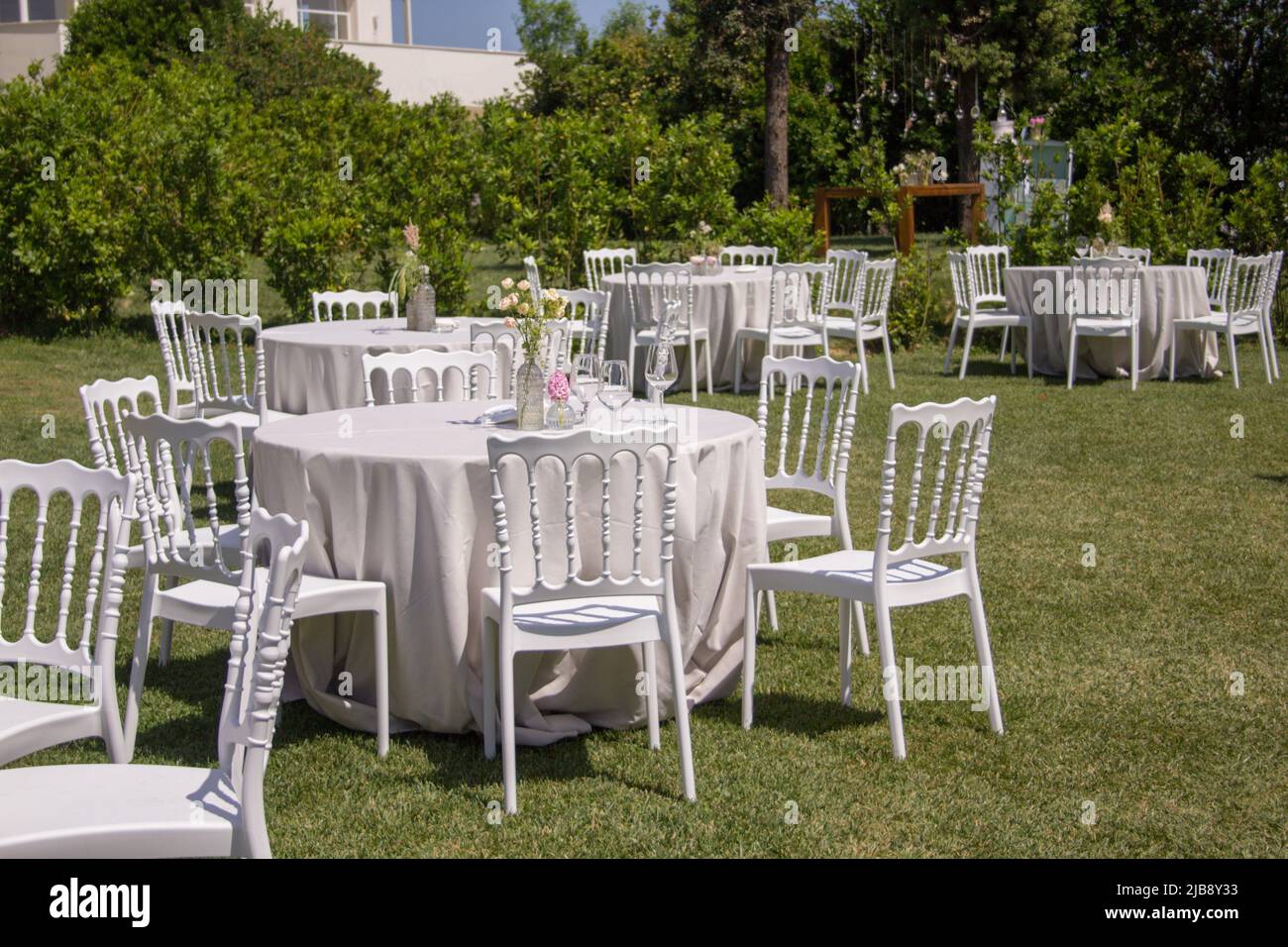 Image of a garden with white tables and chairs set up for a banquet ...