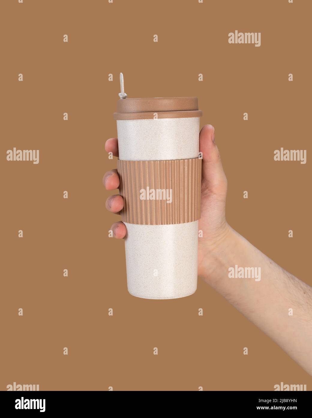 Refillable cup in young mans hand on beige background. Concept of ...