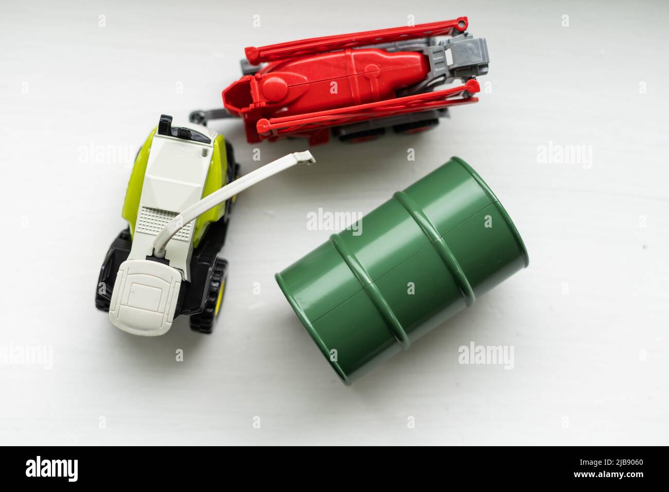 small toy combine with toy oil barrel on white background Stock Photo ...