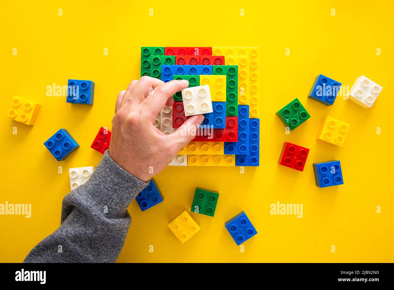 hand stacking up the colorful plastic block Stock Photo - Alamy