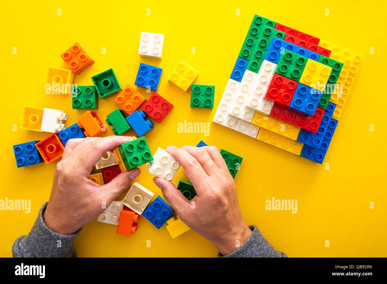 hand stacking up the colorful plastic block Stock Photo - Alamy
