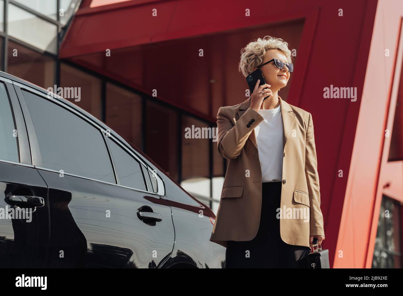 Elegant Business Woman with Briefcase in Hand Talking on the Phone Near ...